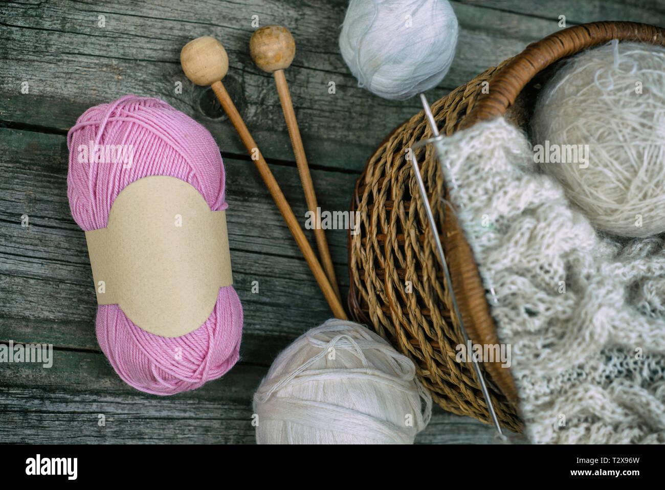 One pink balls of wool threads with empty labels lying on vintage wood ...