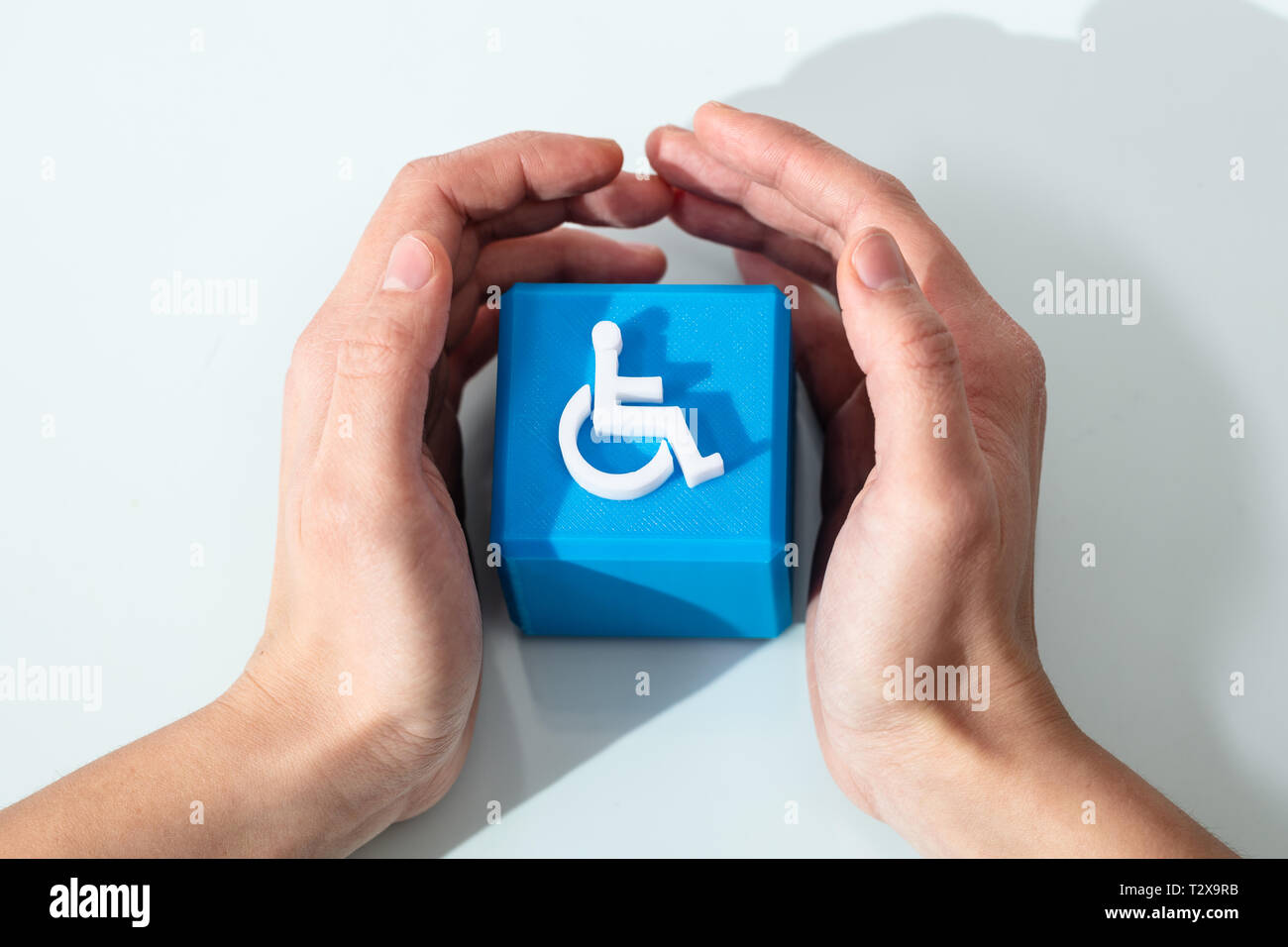 Close-up Of A Human's Hand Protecting Blue Cubic Block With Disabled ...