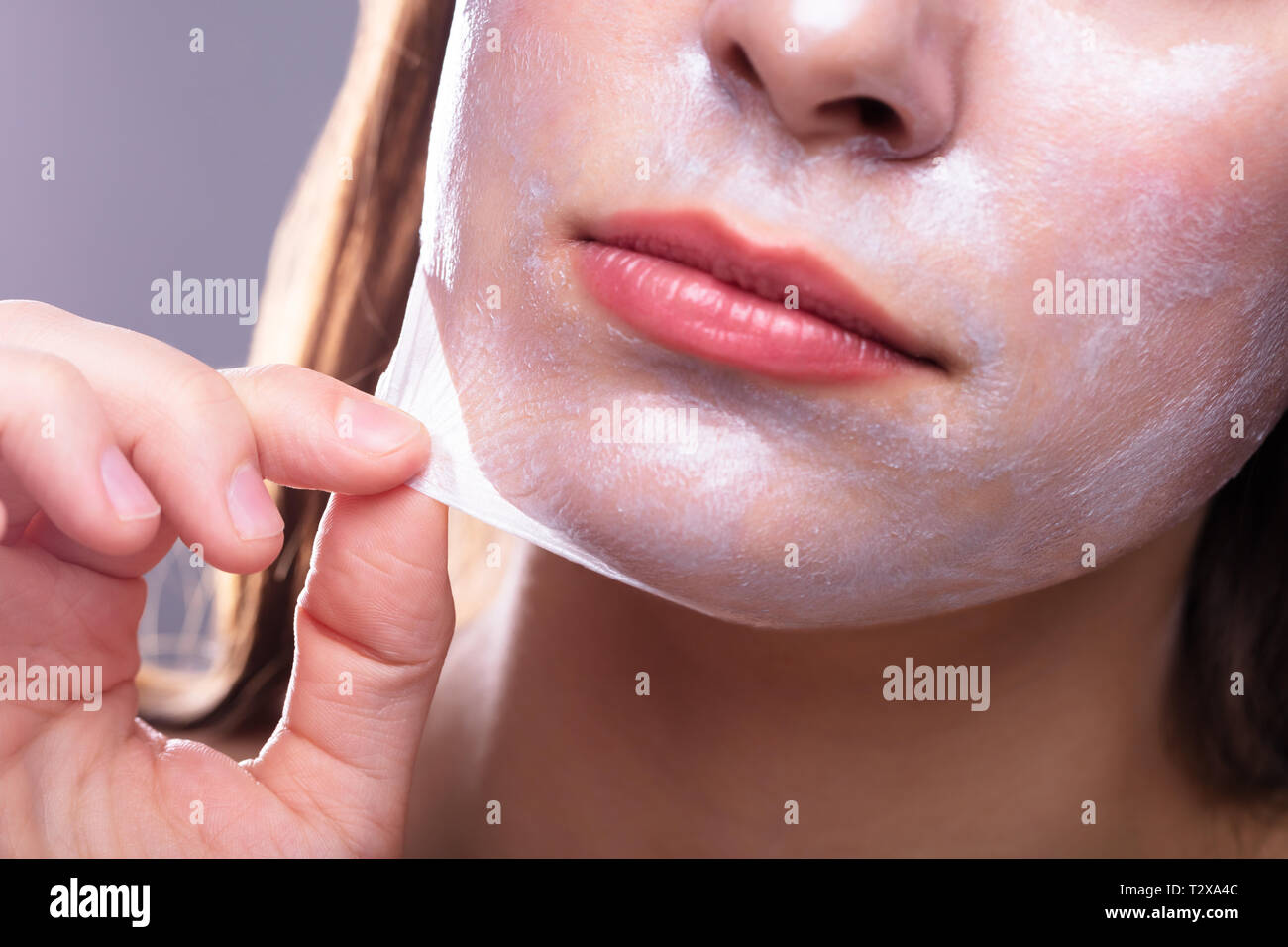 Portrait Of A Beautiful Young Woman Removing Peeling Mask From Her Face ...