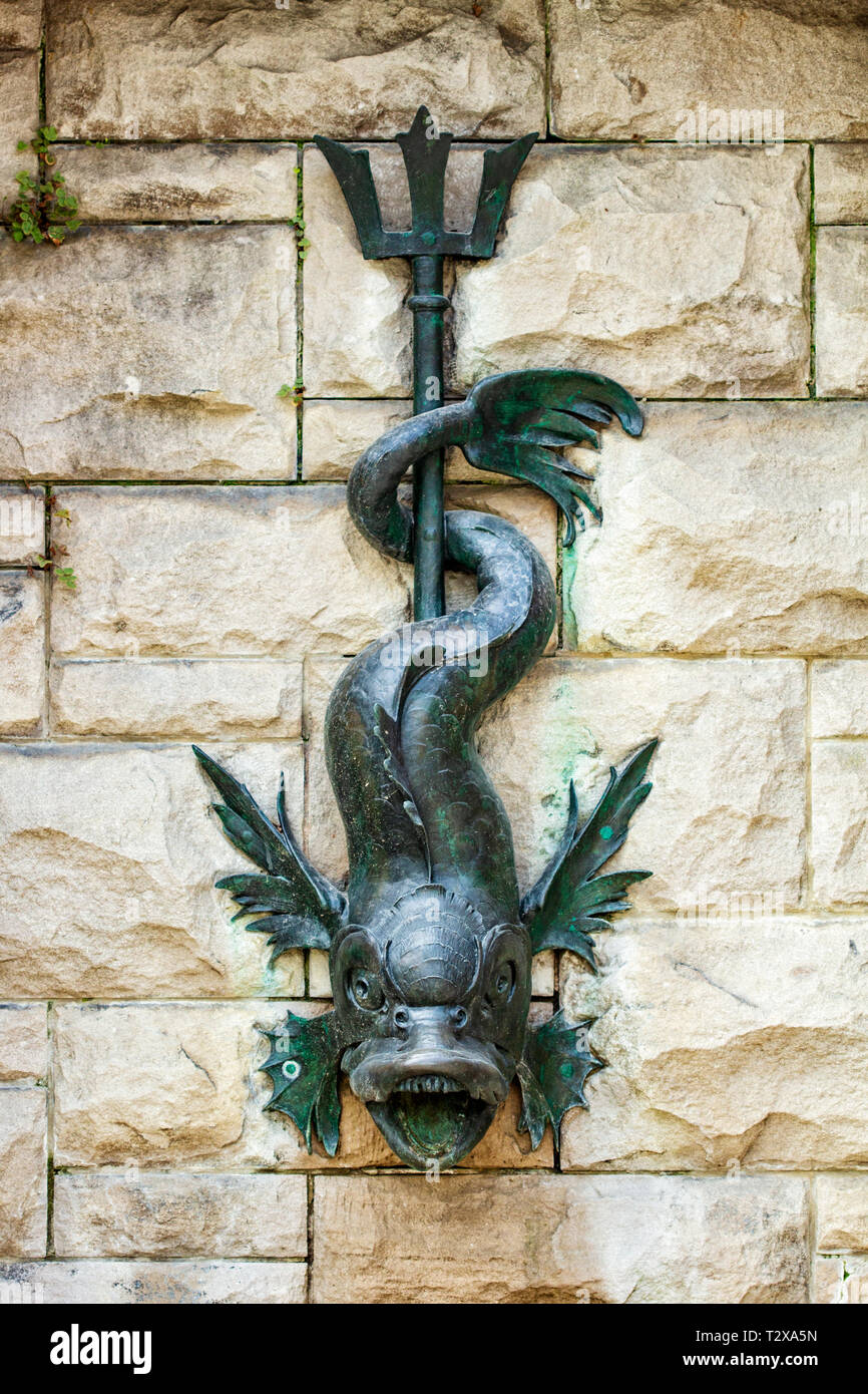 A dragon-fish gargoyle functions as a drainage pipe, surrounded by ...