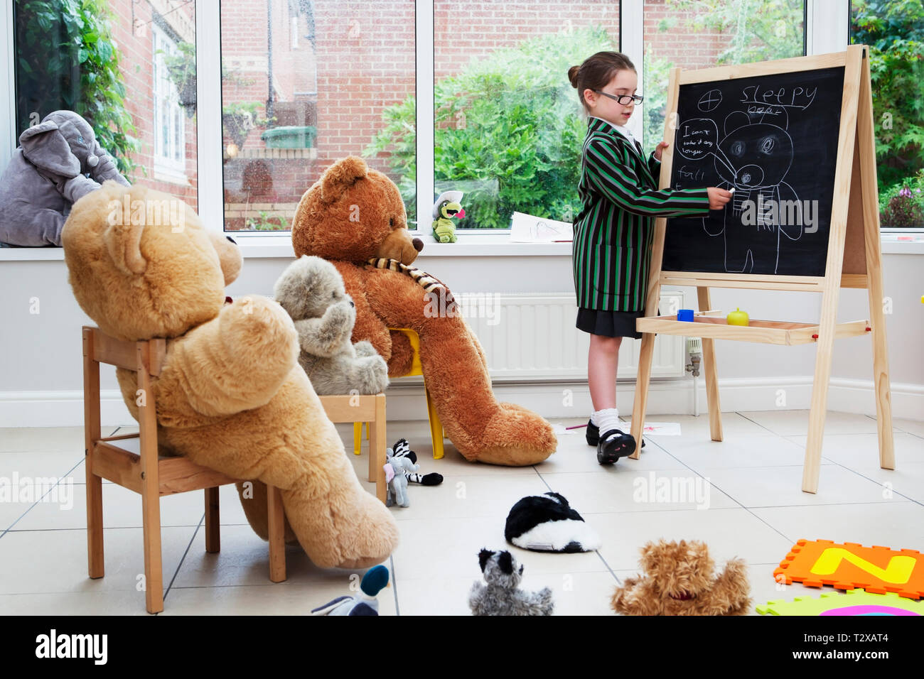 Caucasian girl pretending to teach her teddy bears Stock Photo - Alamy