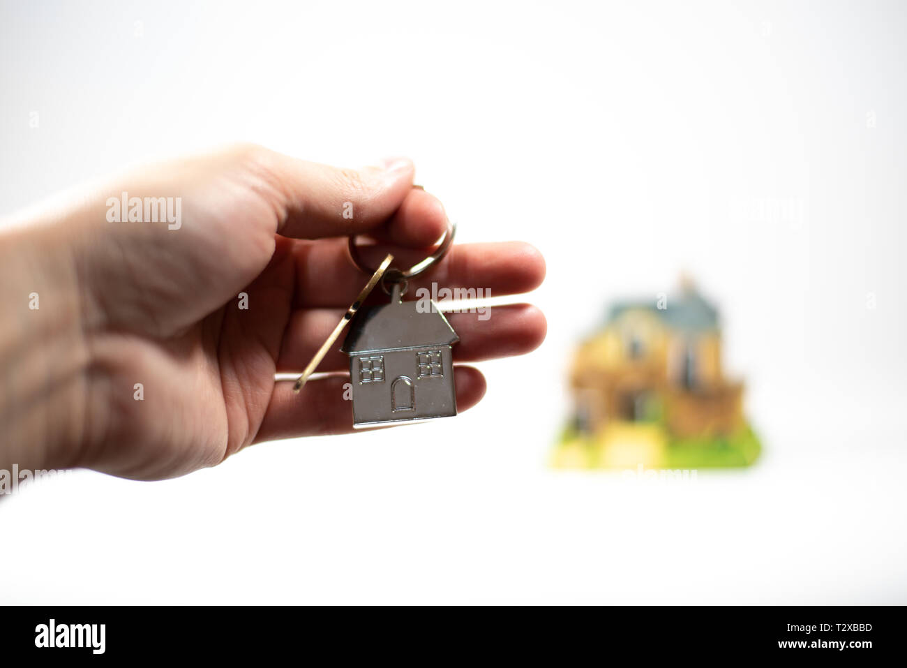 Hand holding a keychain with a key for the house shown in the ...
