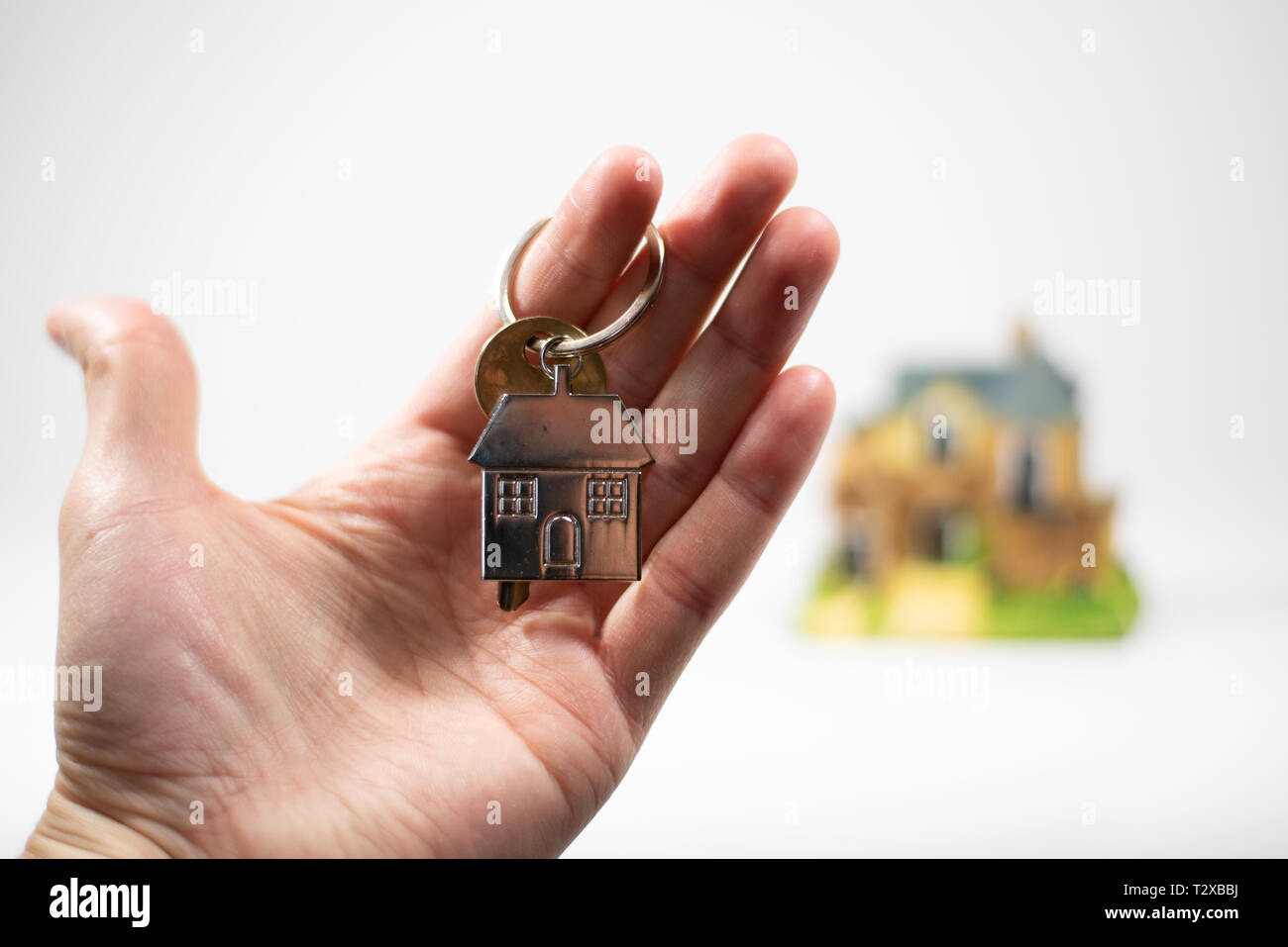 Hand holding a keychain with a key for the house shown in the ...