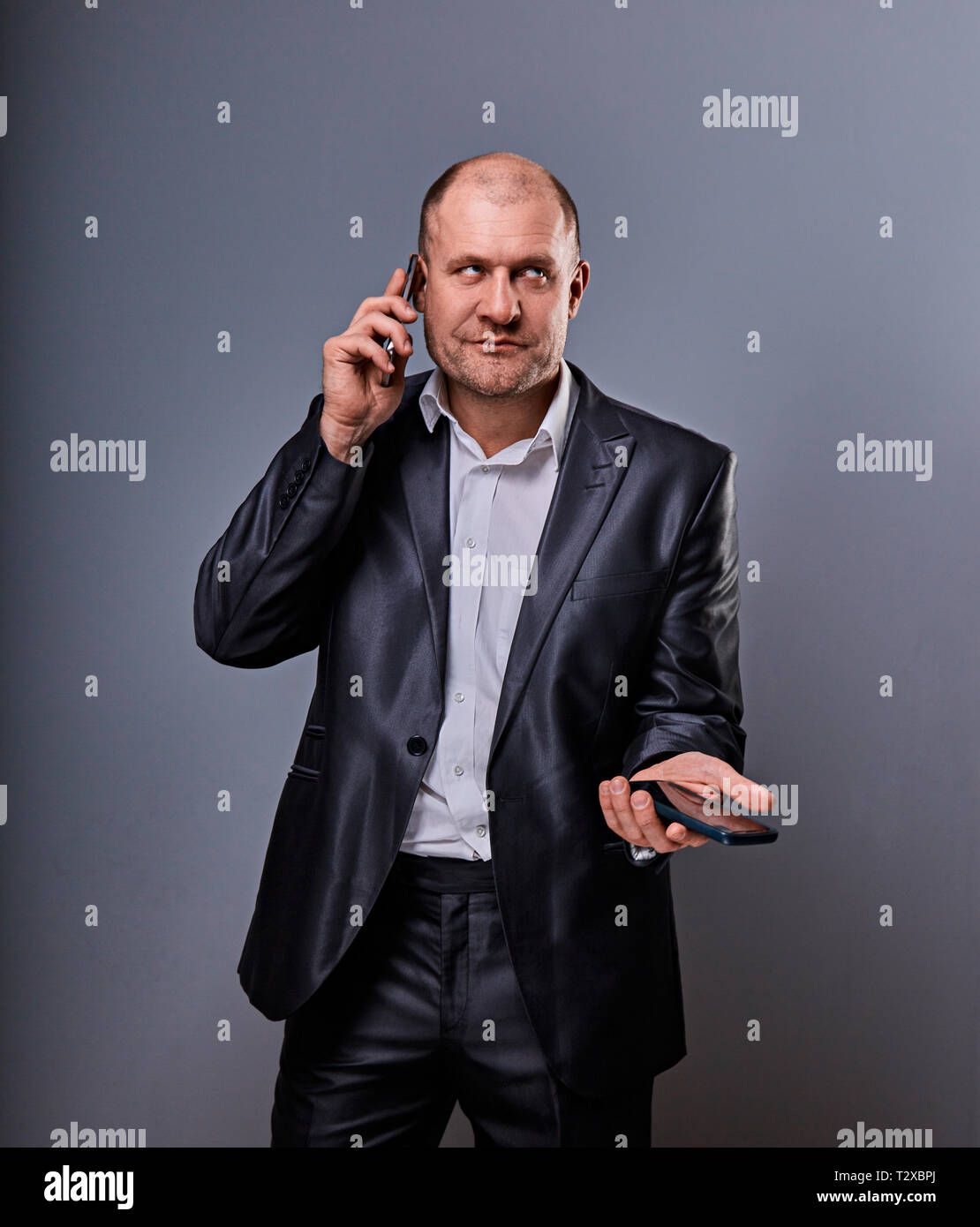 Unhappy tired angry business man talking on mobile phone and holding in ...