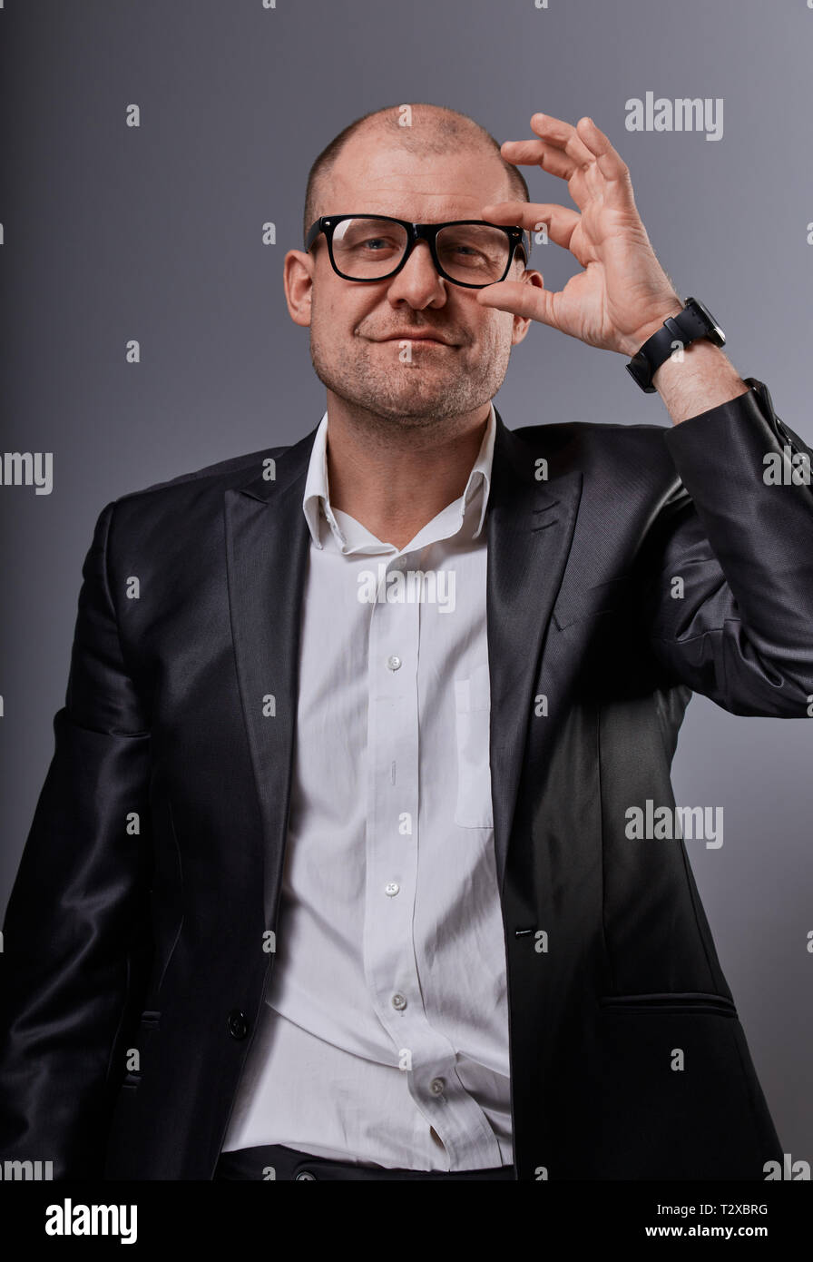 Thinking smiling bald business man looking serious in eyeglasses in ...