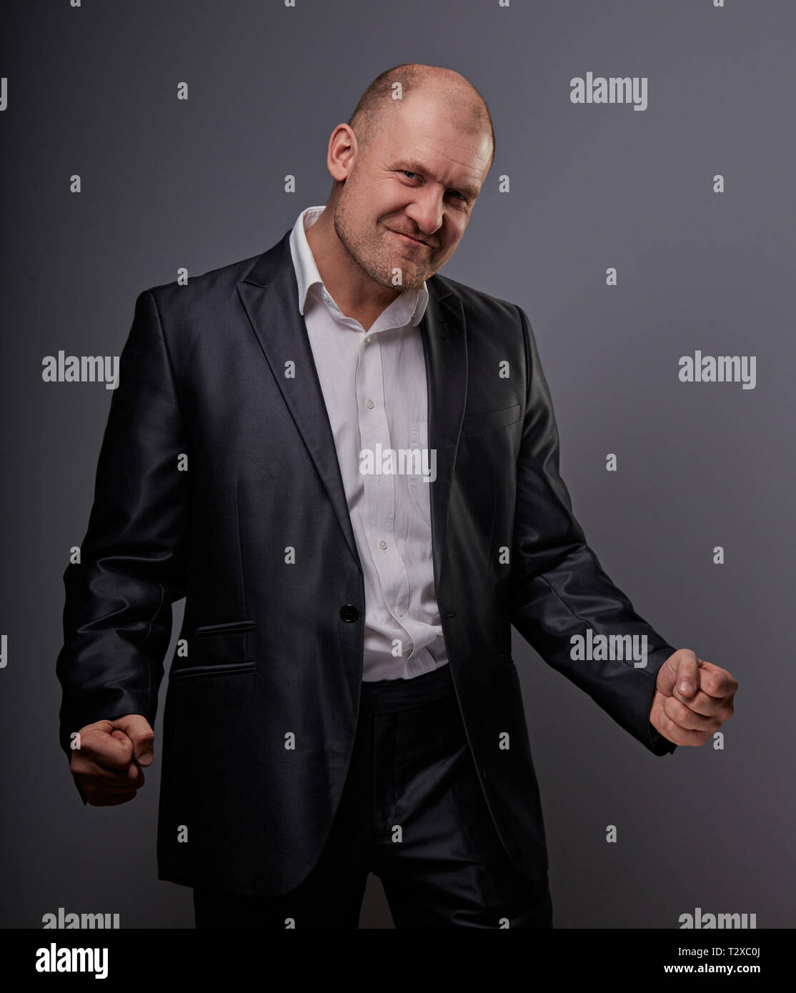 Exited bald business man in black suit showing the hands success winner ...