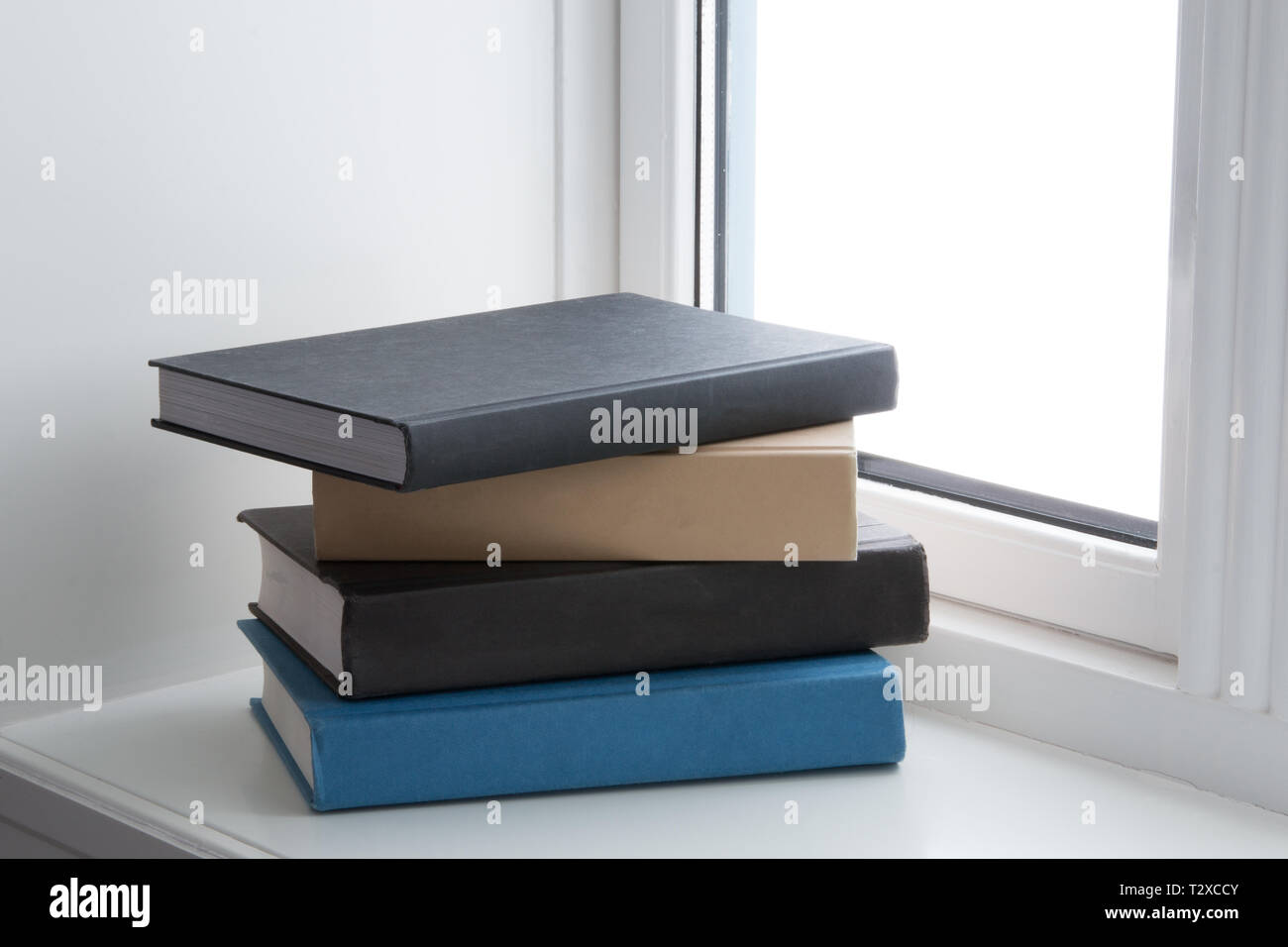 Books stacked in windowsill Stock Photo - Alamy