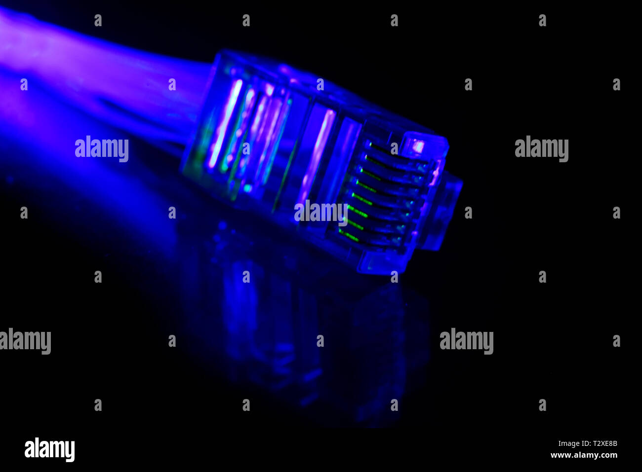 Network connection plug with fiber optics cable isolated on black ...