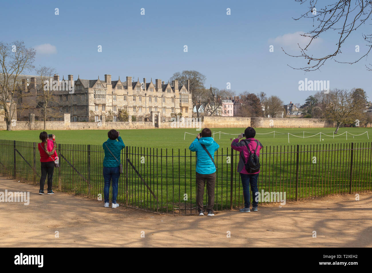 Tourists photograph Merton College Oxford across Merton Field from ...