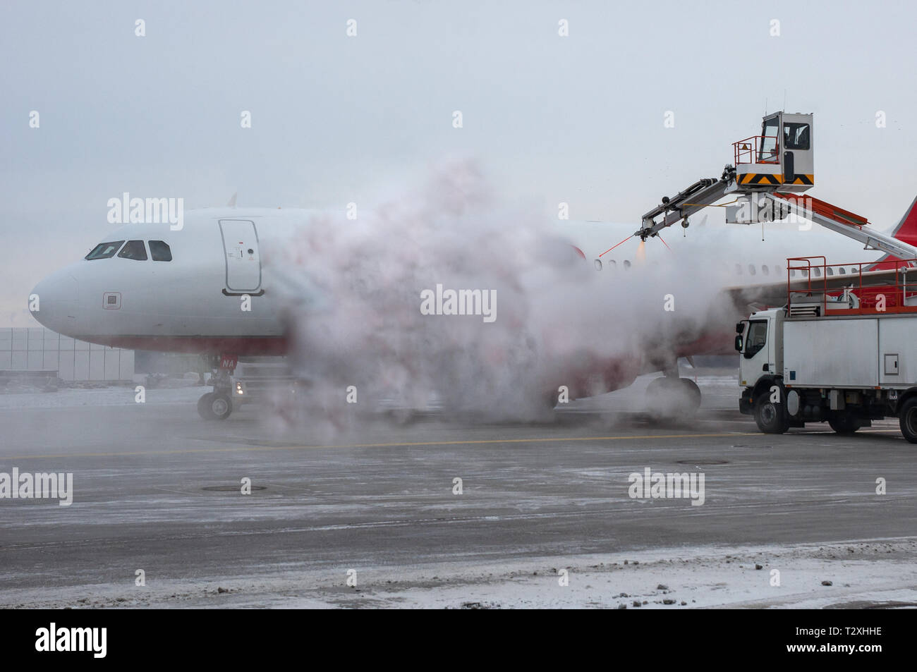 Passenger airplane deicing at airport Stock Photo - Alamy