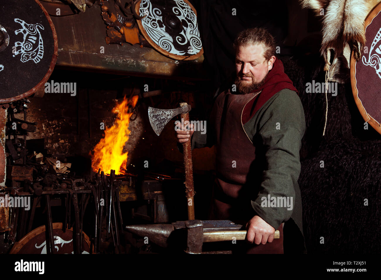 Viking forges weapons and swords in the smithy. A man in a warrior's ...
