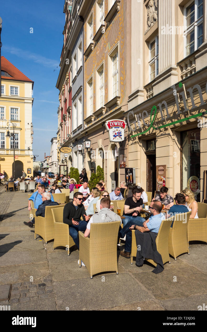 People men and women sitting outside eating and drinking at cafes in ...