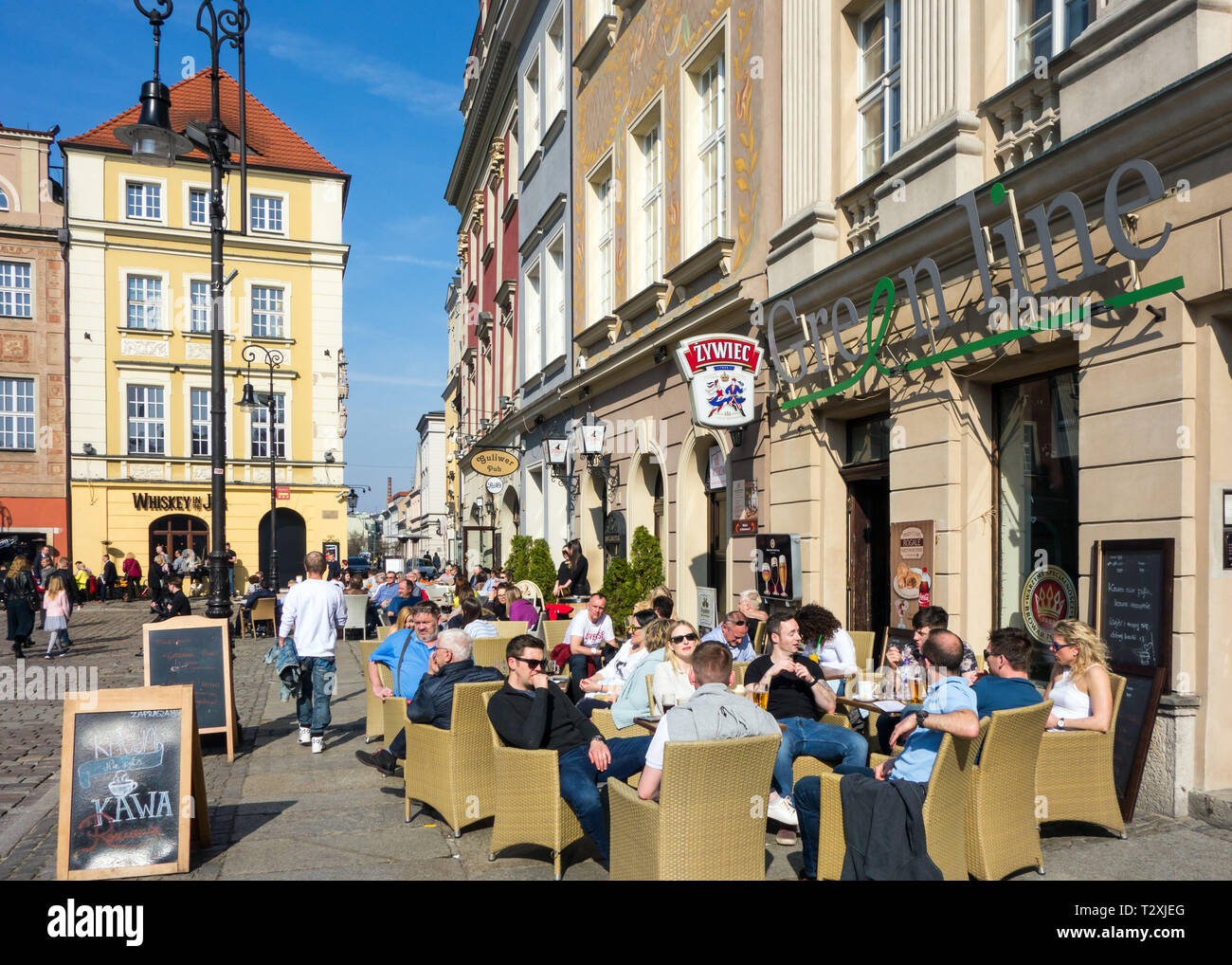 People men and women sitting outside eating and drinking at cafes in ...