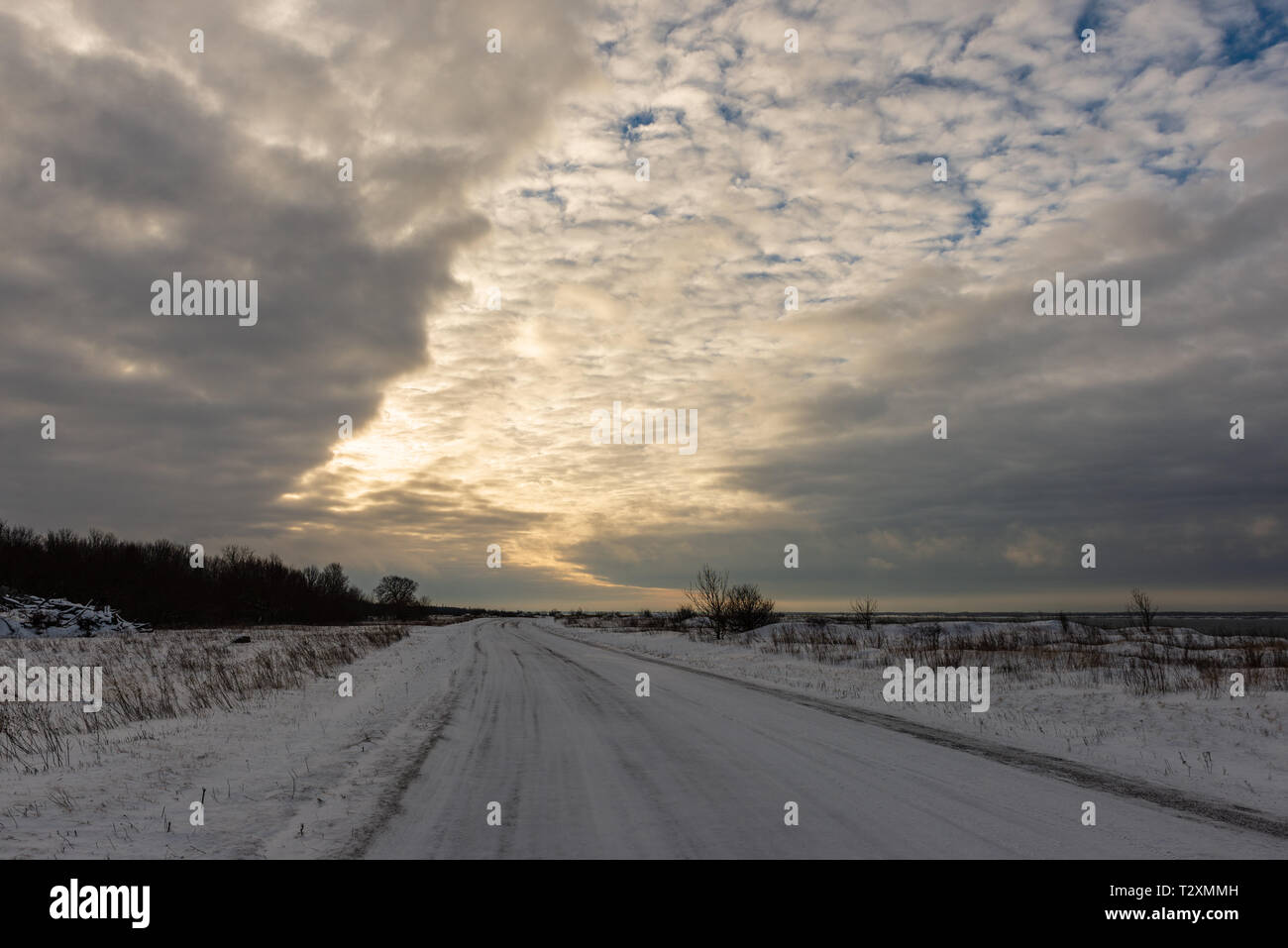 snowy winter road covered in ice and snow in forest woth blue sky Stock ...