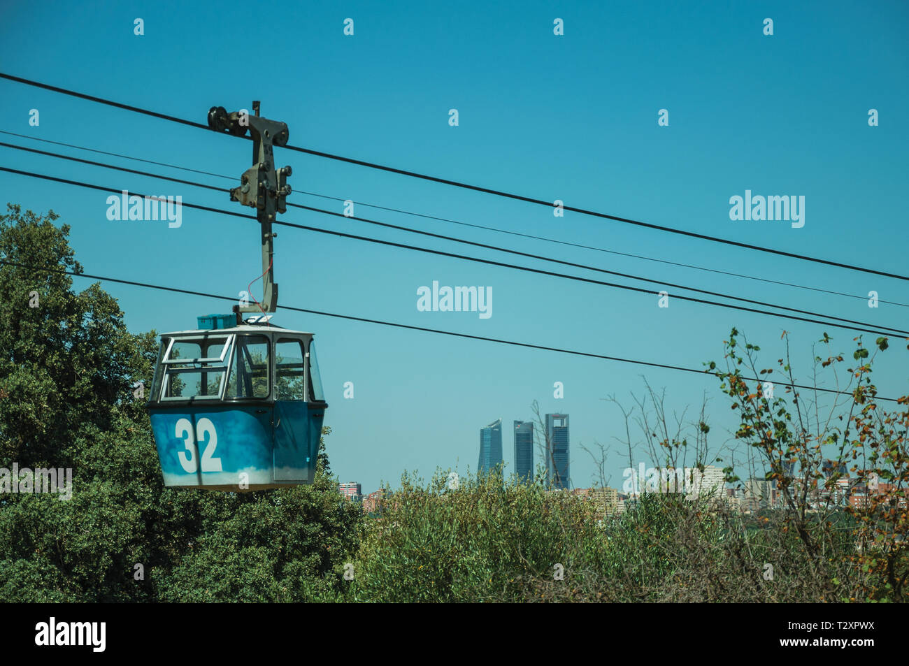 Cable car gondola passing through leafy trees and buildings at the ...