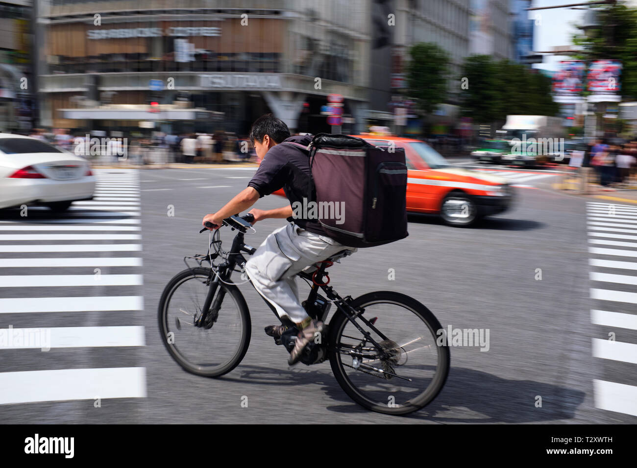 Pictured is a delivery cyclist at Shibuya crossing Tokyo, Japan Stock ...
