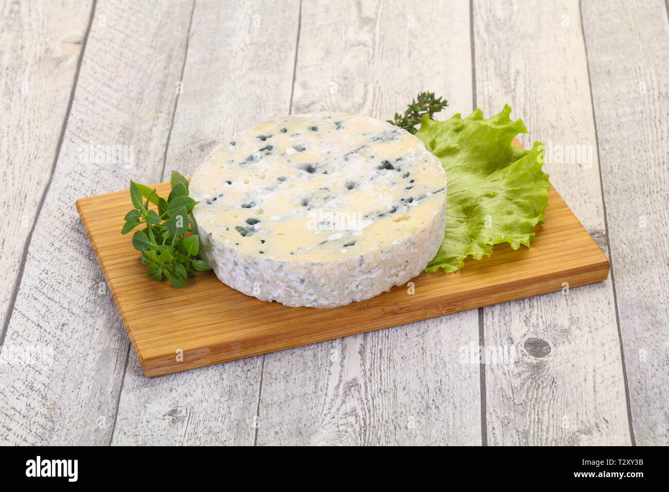 Round blue cheese with salad and basil Stock Photo - Alamy