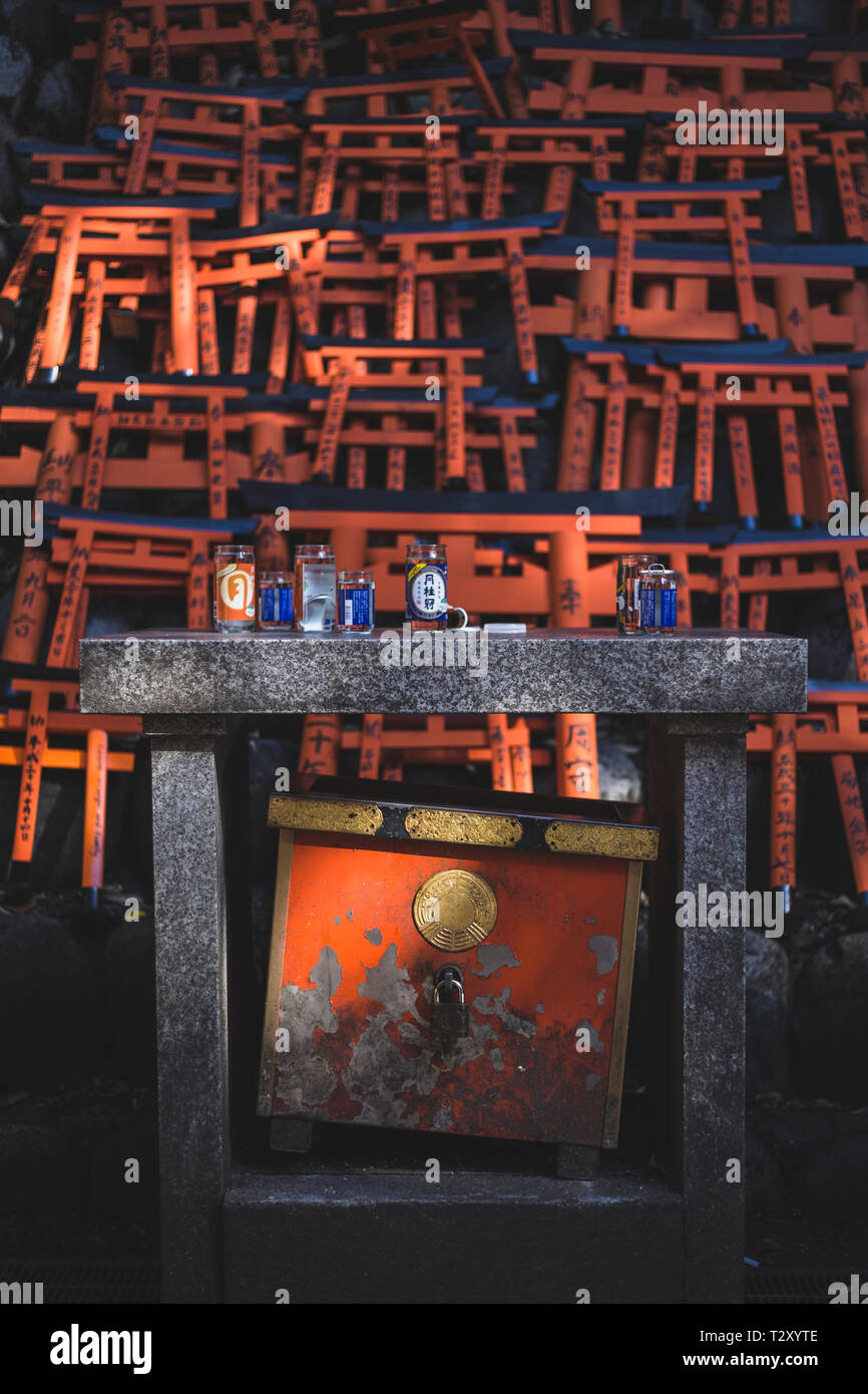 Small altar with torii gates in the background at Fushimi Inari shrine ...