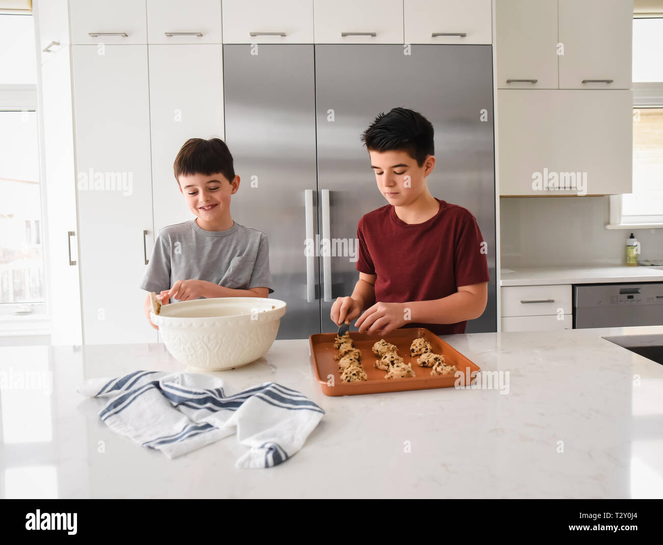 Two boys happily baking cookies together in a modern kitchen Stock ...