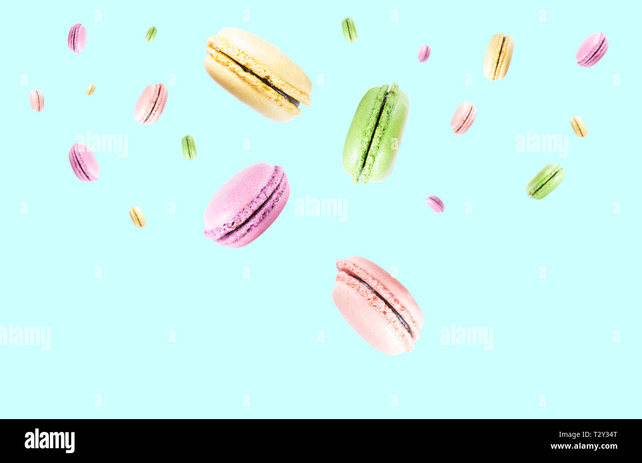 colorful macaroons flying in the air at soft blue background Stock ...
