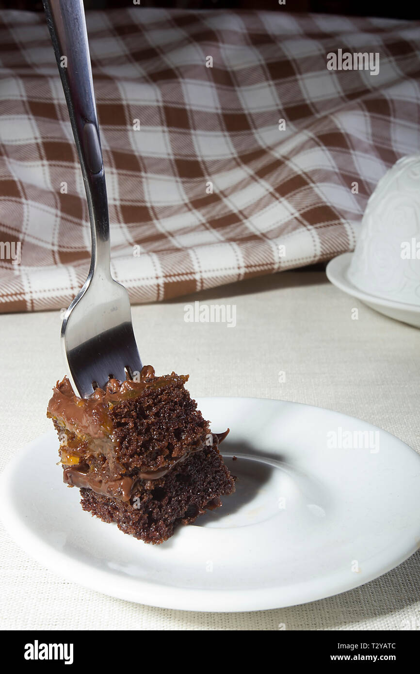 Cake with a fork in a plate on the dining table Stock Photo - Alamy