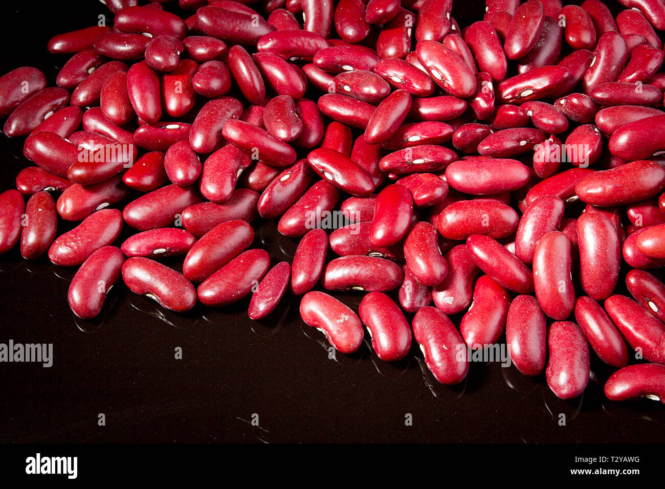Red beans on a black reflective surface Stock Photo - Alamy