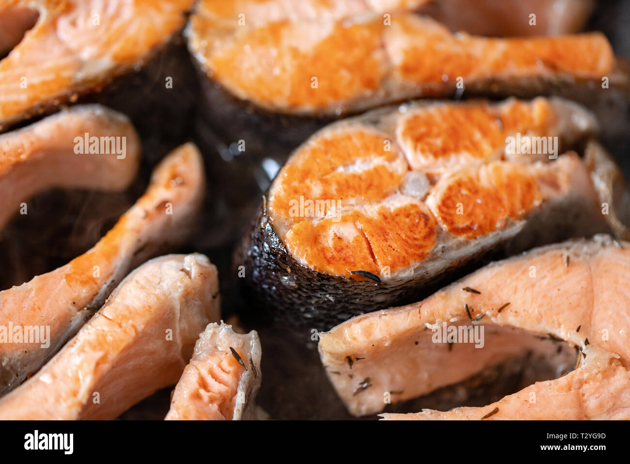 Close-up of roasted salmon steaks in a frying pan, top view. Fresh ...