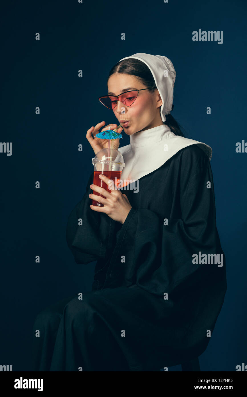 Forbidden taste. Medieval young woman as a nun in vintage clothing and ...