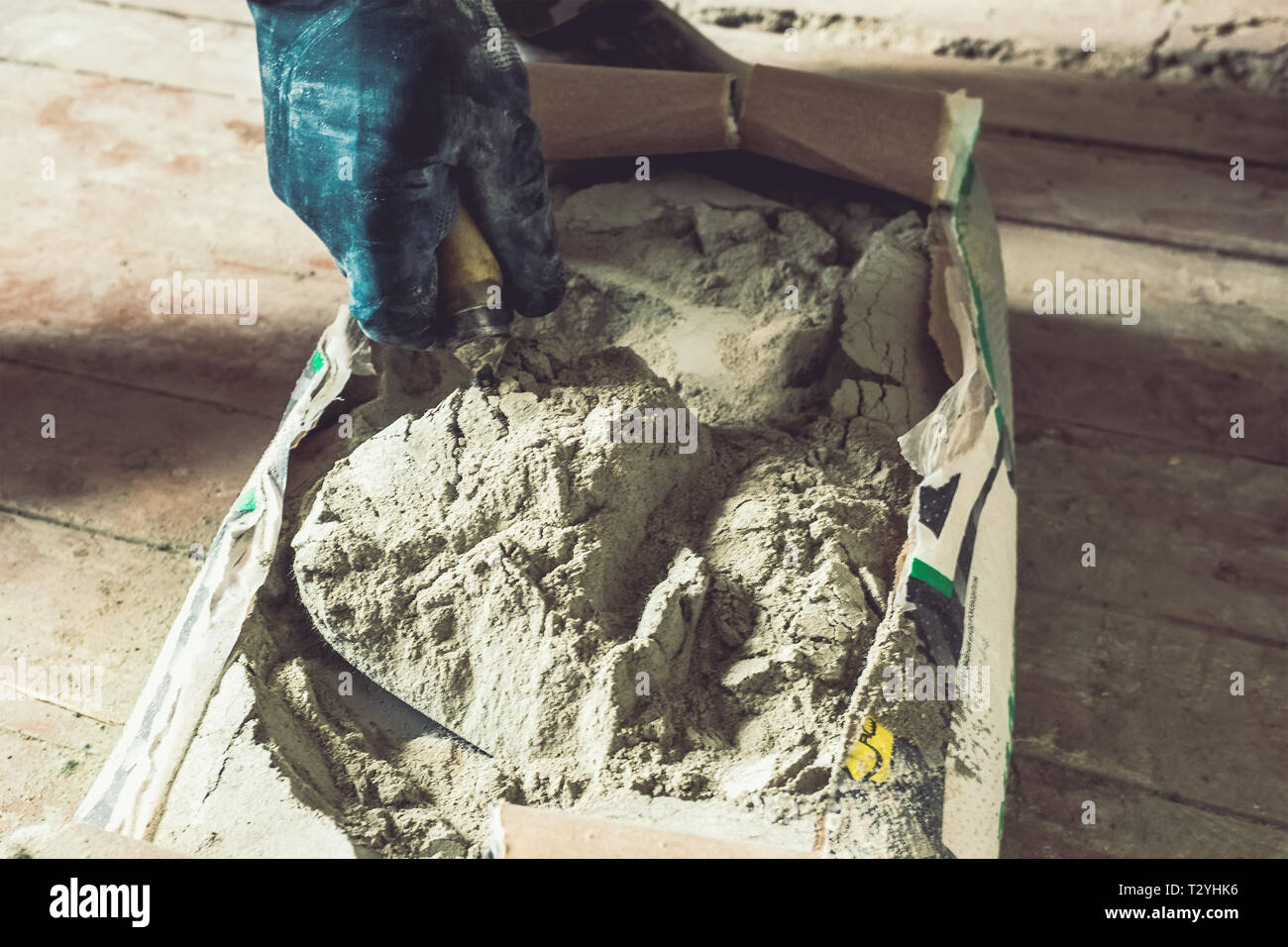 Cement powder in the cement bag, a hand hold the trowel scoop cement ...