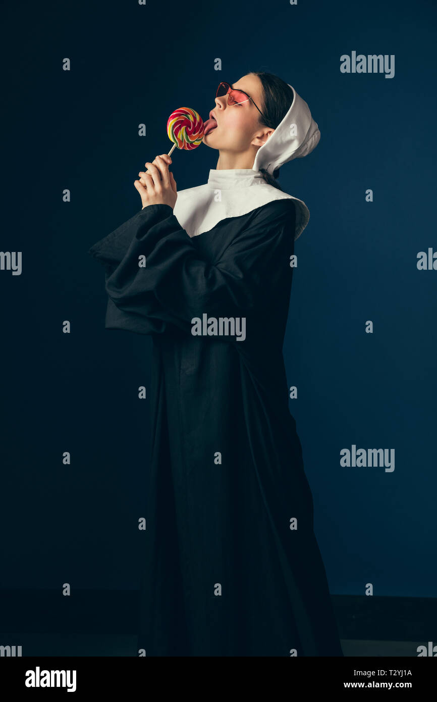 Sweet taste of freedom. Medieval young woman as a nun in vintage ...