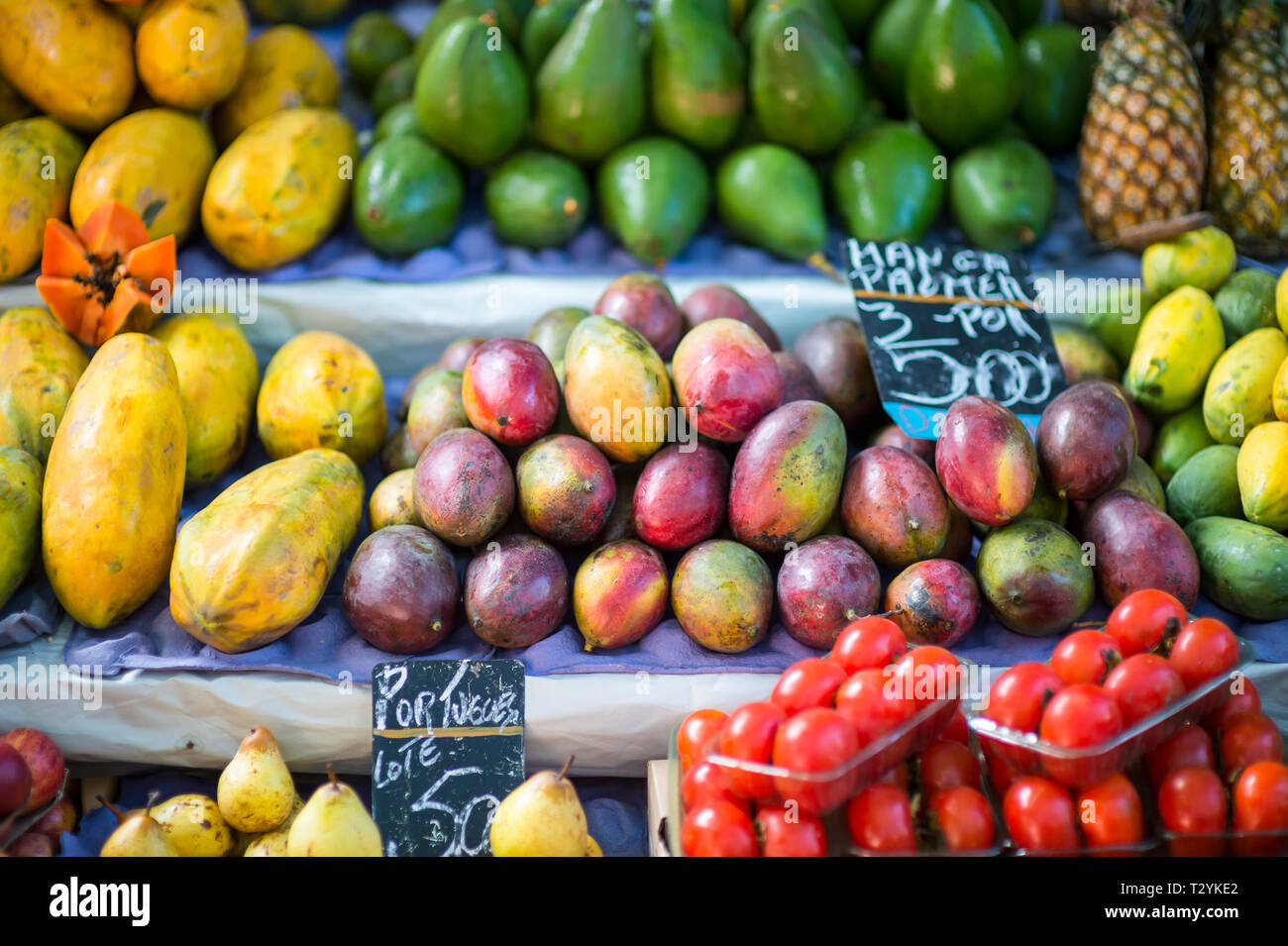Colorful piles of tropical mangoes, papayas, and other fruits at an ...