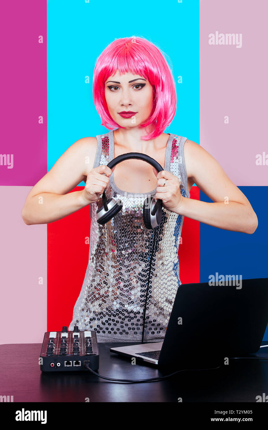 Glamorous DJ girl with pink hair and headphne on red, pink and blue ...