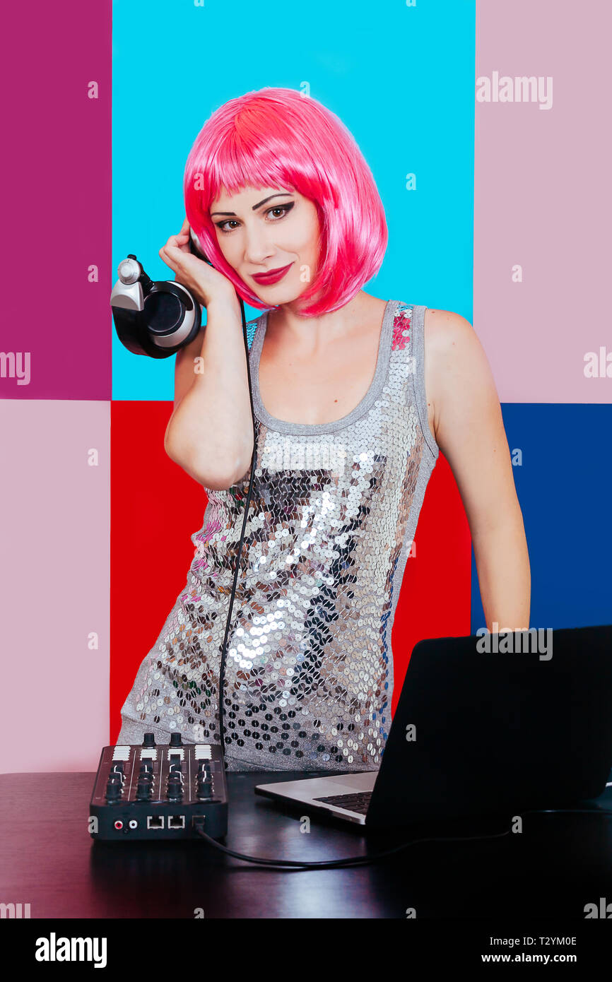 Glamorous DJ girl with pink hair and headphne on red, pink and blue ...