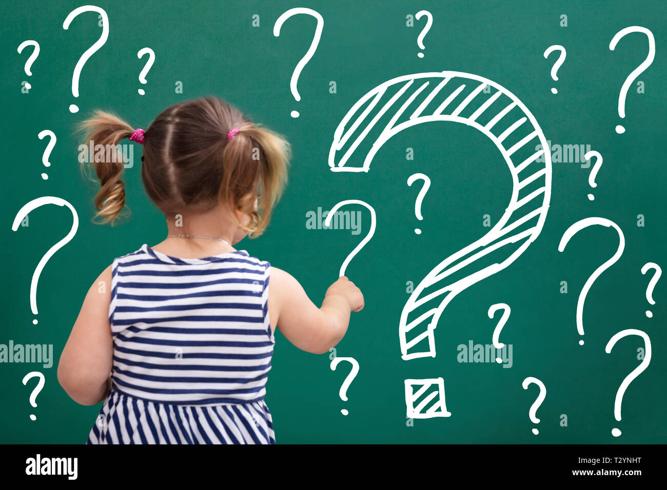 Rear View Of Little Girl Writing Question Marks On Chalkboard Stock ...