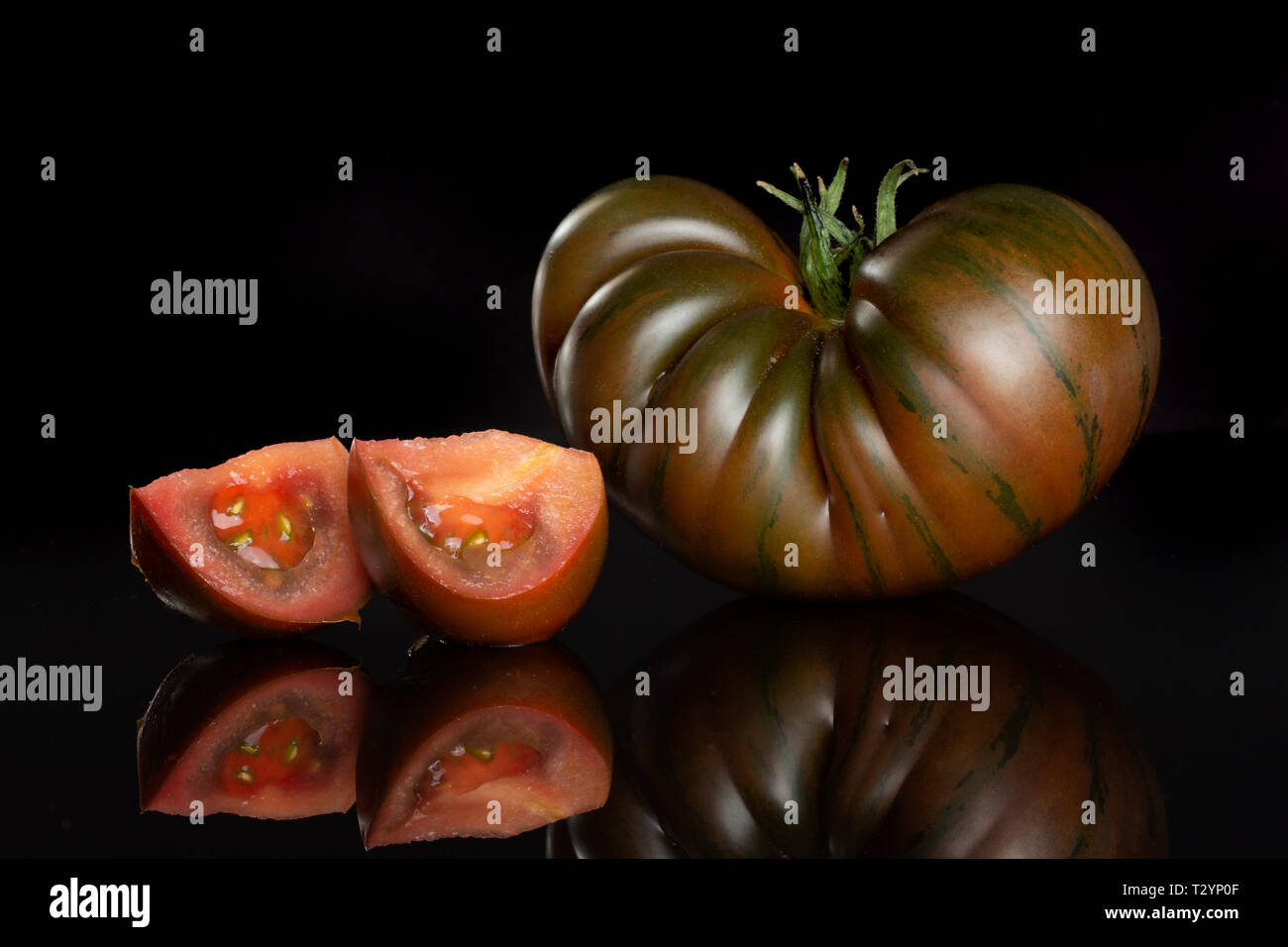 Group of one whole two slices of fresh tomato primora isolated on black ...