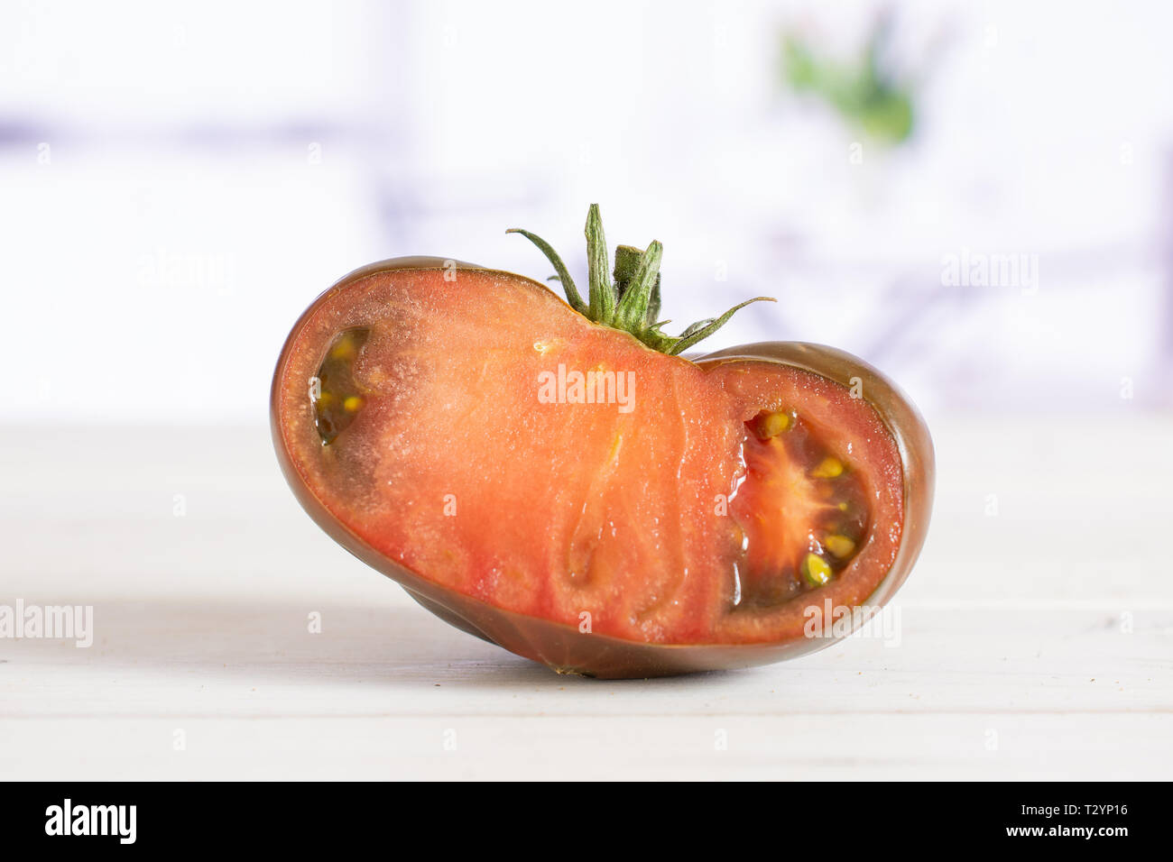 One half of fresh tomato primora in a white kitchen with flowers Stock ...