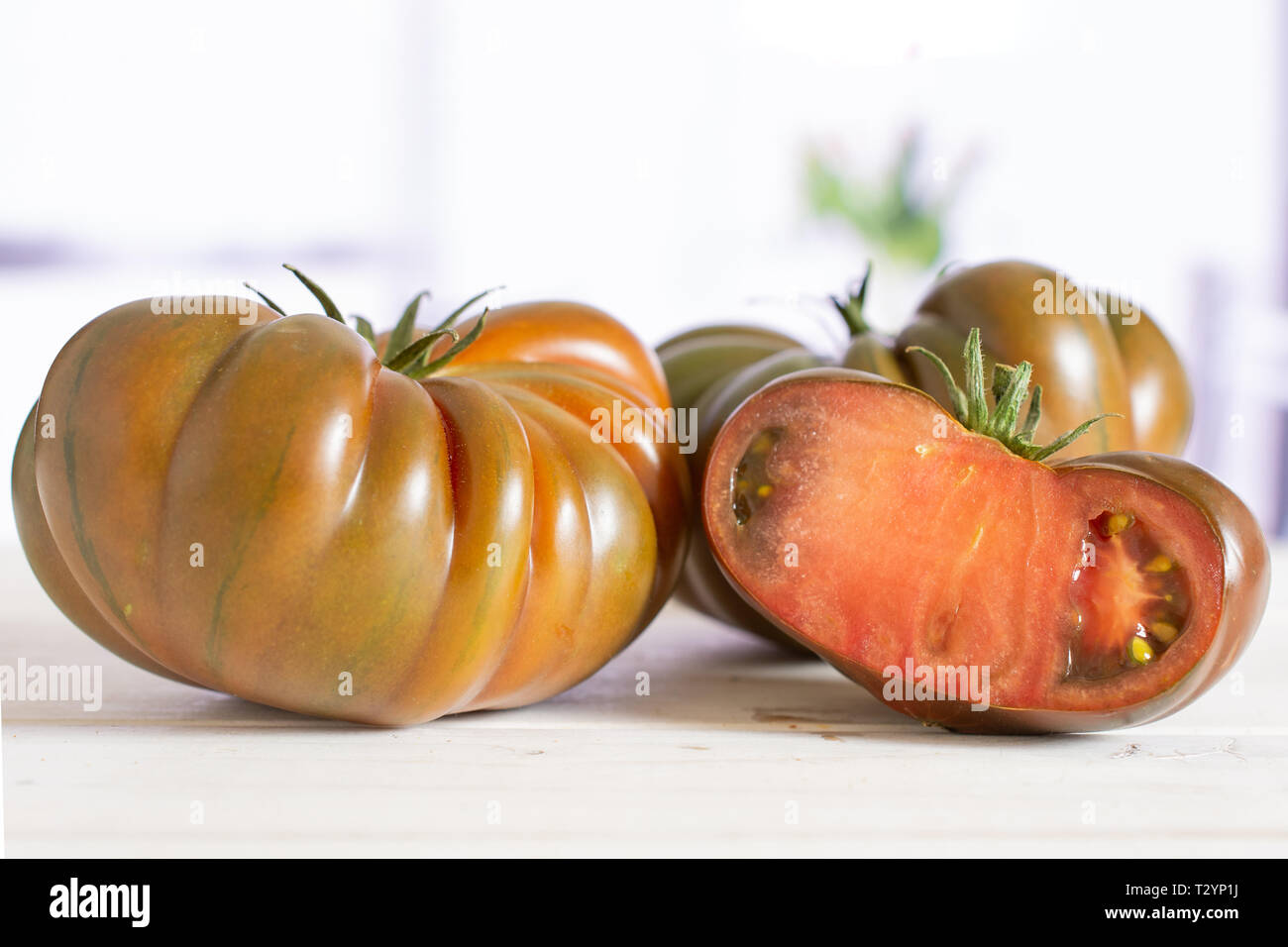 Group of two whole one half of fresh tomato primora in a white kitchen ...
