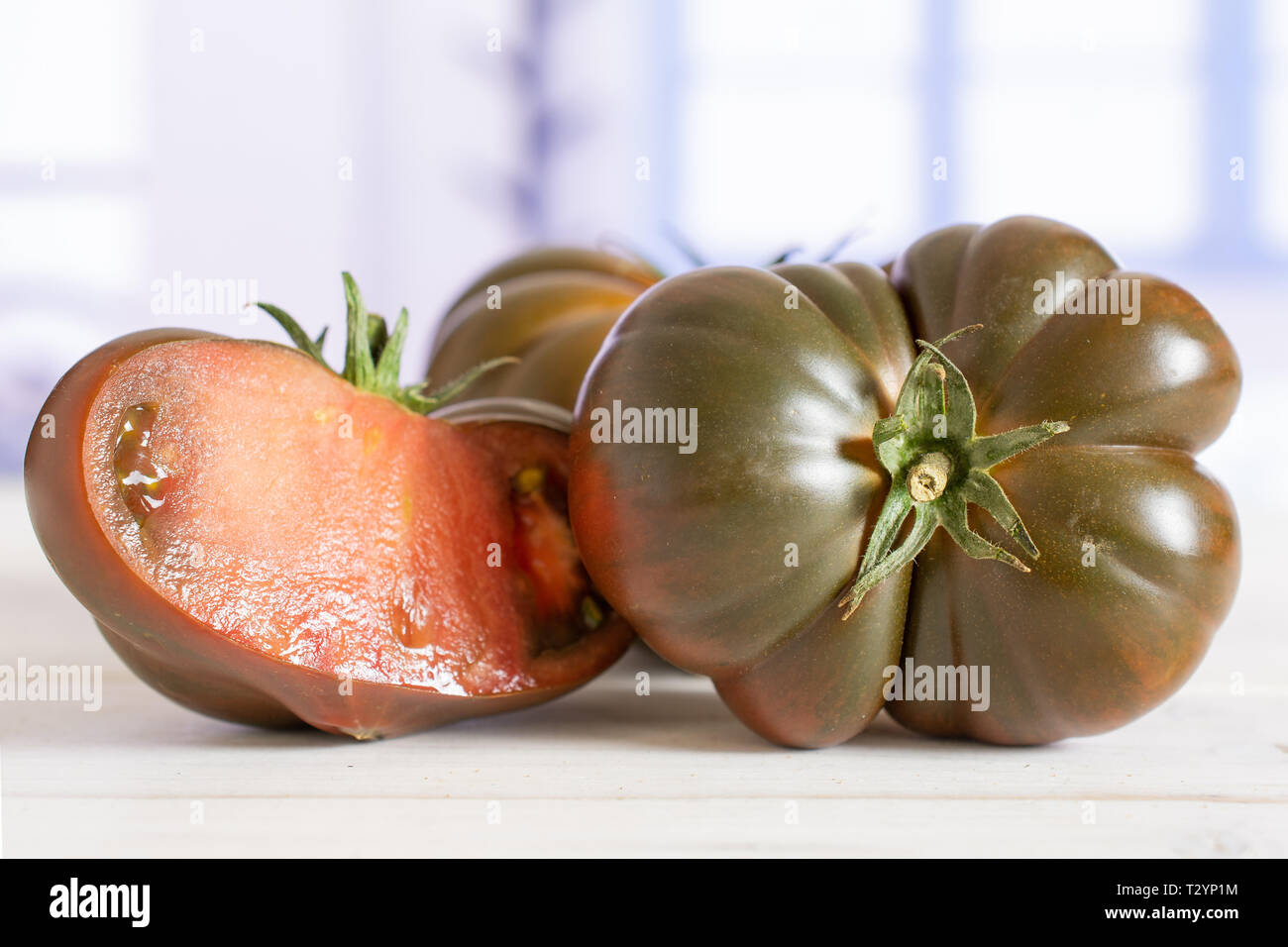 Group of one whole one half of dark fresh tomato primora with blue ...
