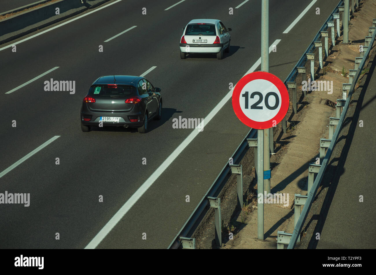 Cars passing through highway and SPEED LIMIT signpost in Madrid ...