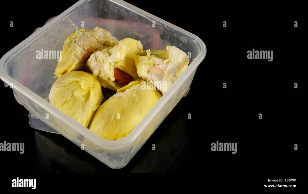 close up of creamy durian fruit inside plastic container isolated in ...