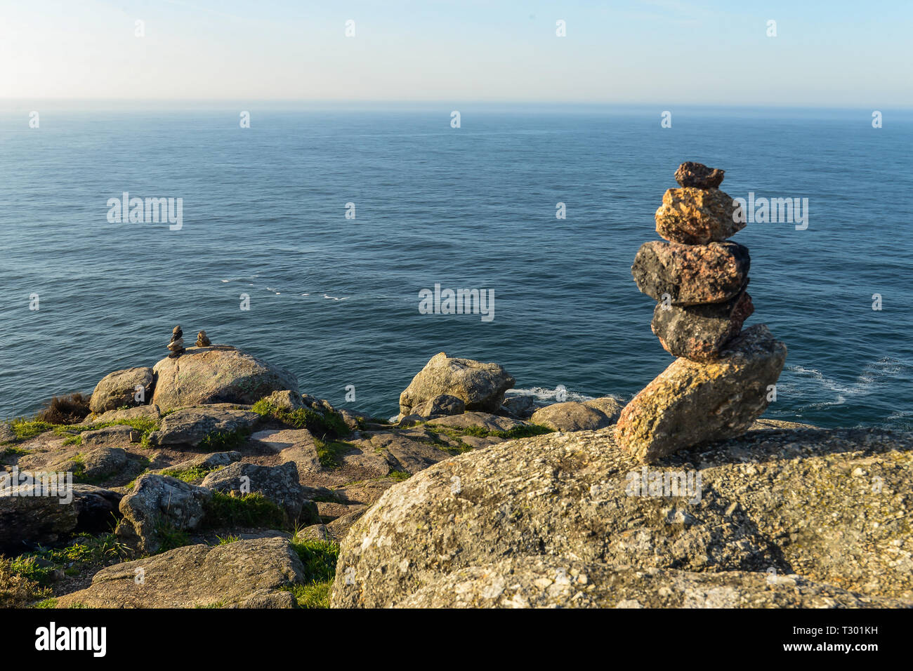 Rocks stacked around the lighthouse at the end of the camino de ...
