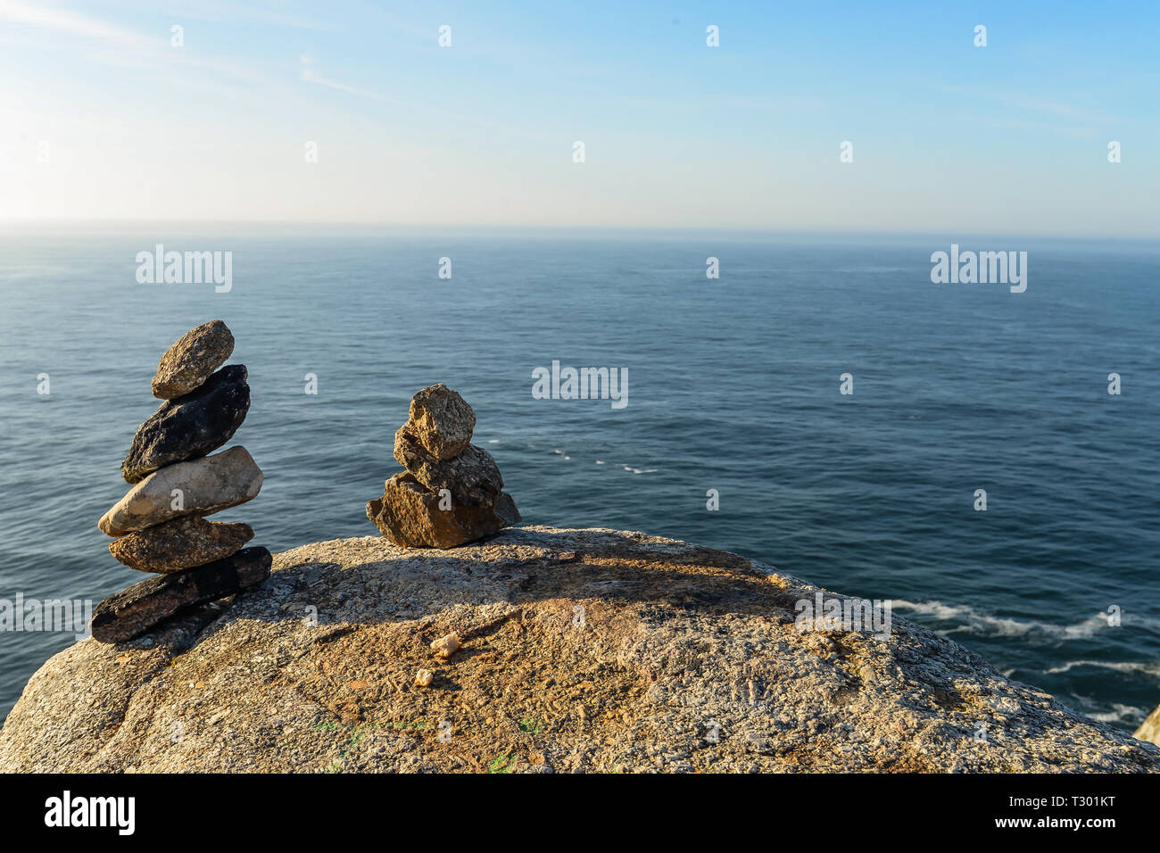 Rocks stacked around the lighthouse at the end of the camino de ...