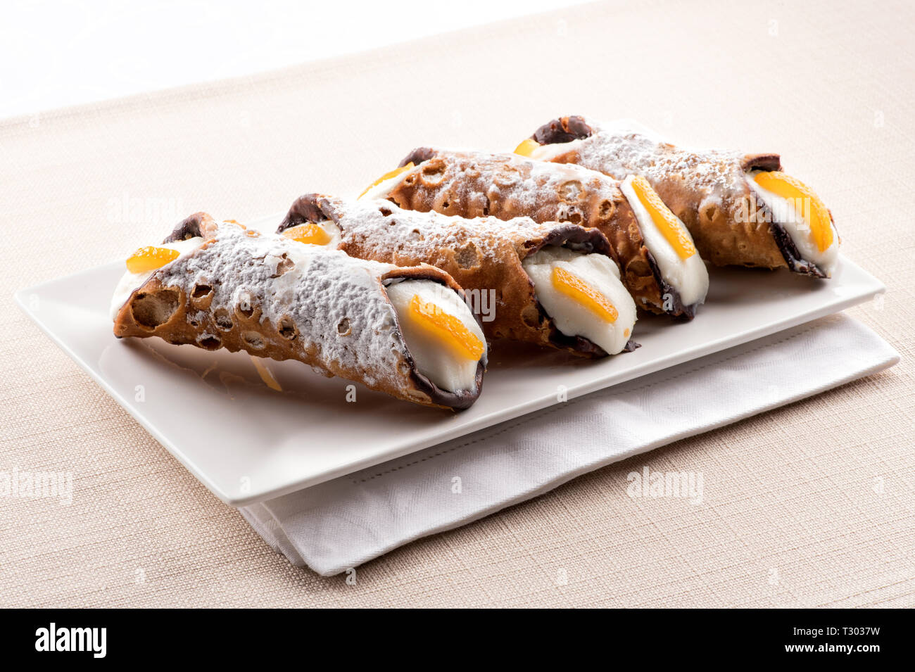 Four cannoli Sicilia, or Sicilian cannoli, deep fried pastry tubes with ...