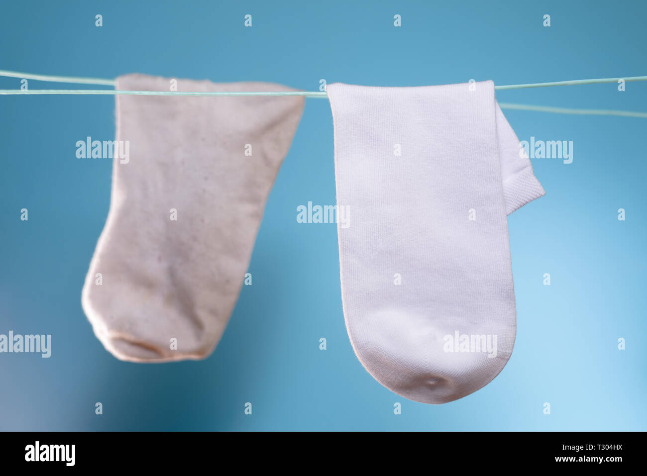 clean new white sock and next to the dirty old sock weighs. concept ...