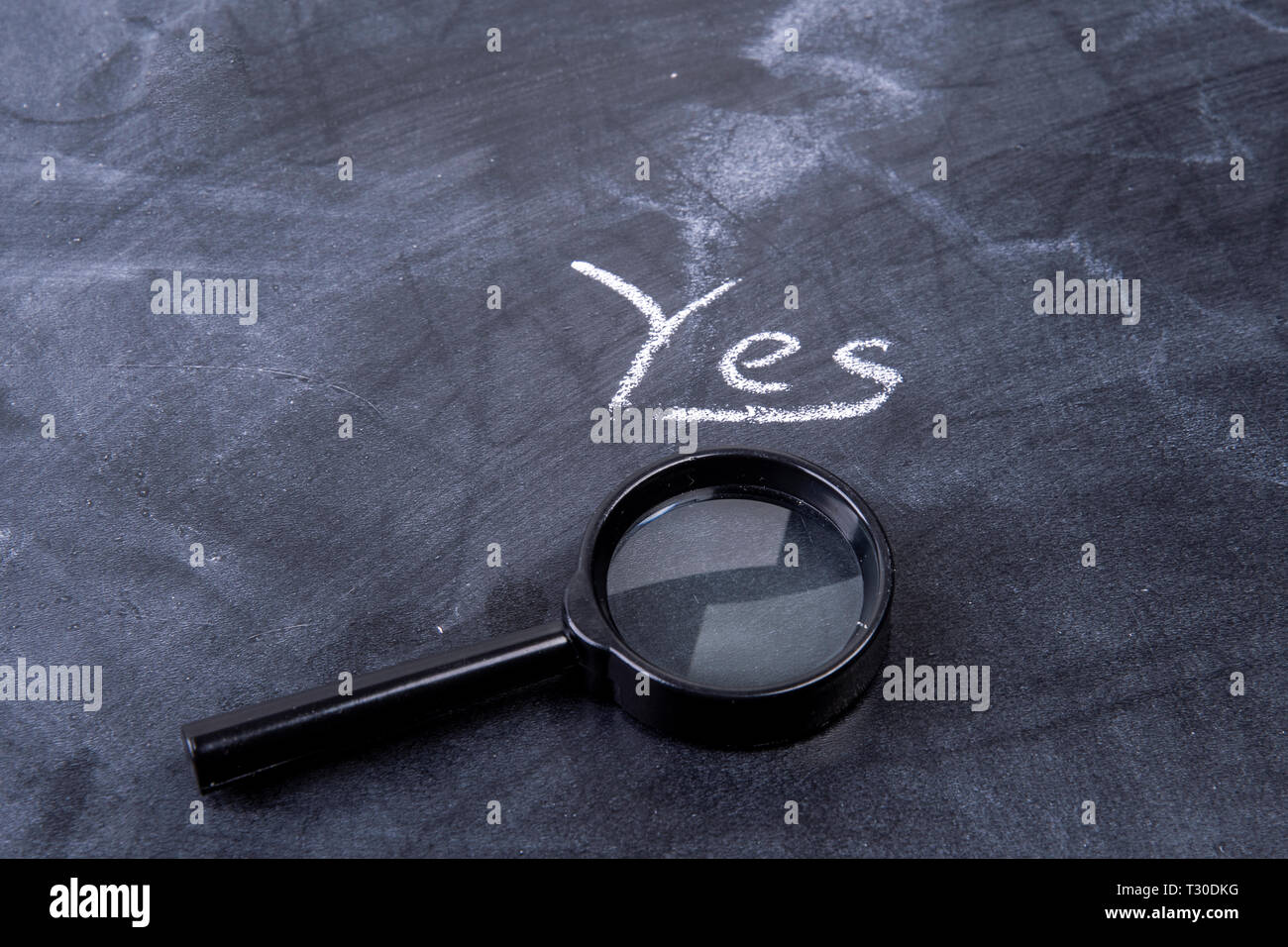 blackboard with the word yes and a magnifying glass Stock Photo - Alamy