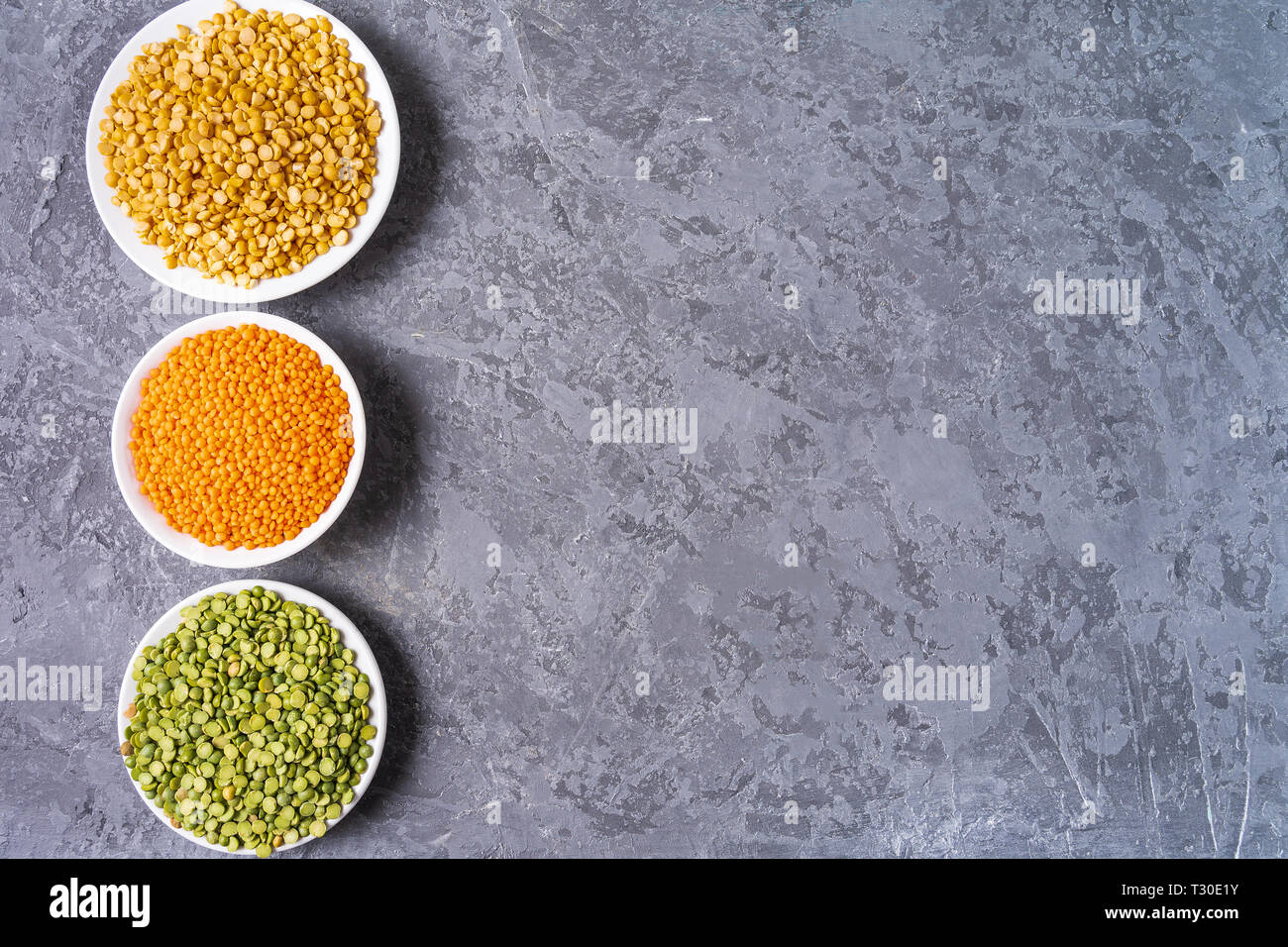 Top view of assortment of peas, lentils, beans and legumes over gray ...