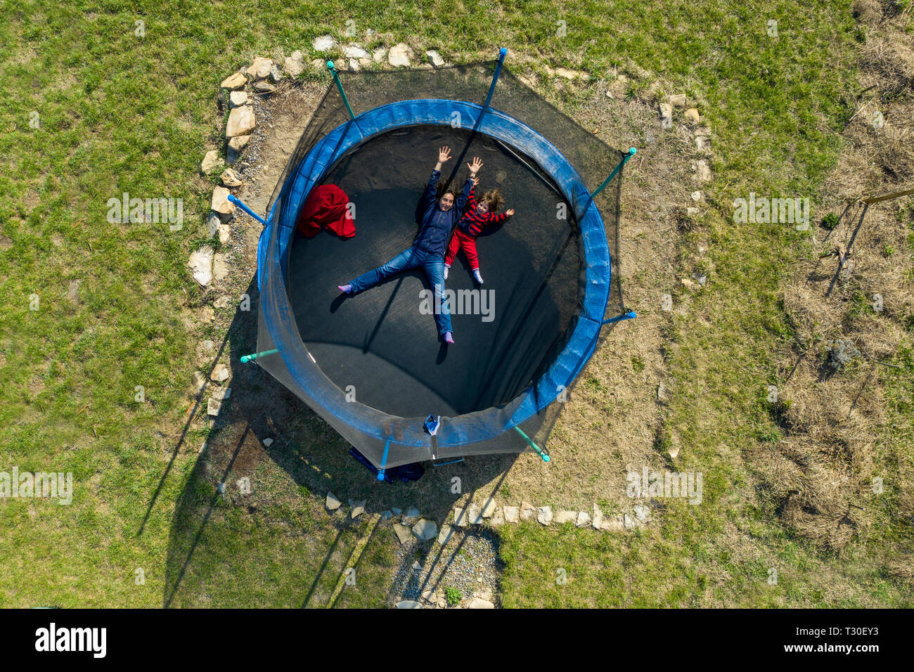 Aerial point of view of mother with her daughter having fun and jumping ...