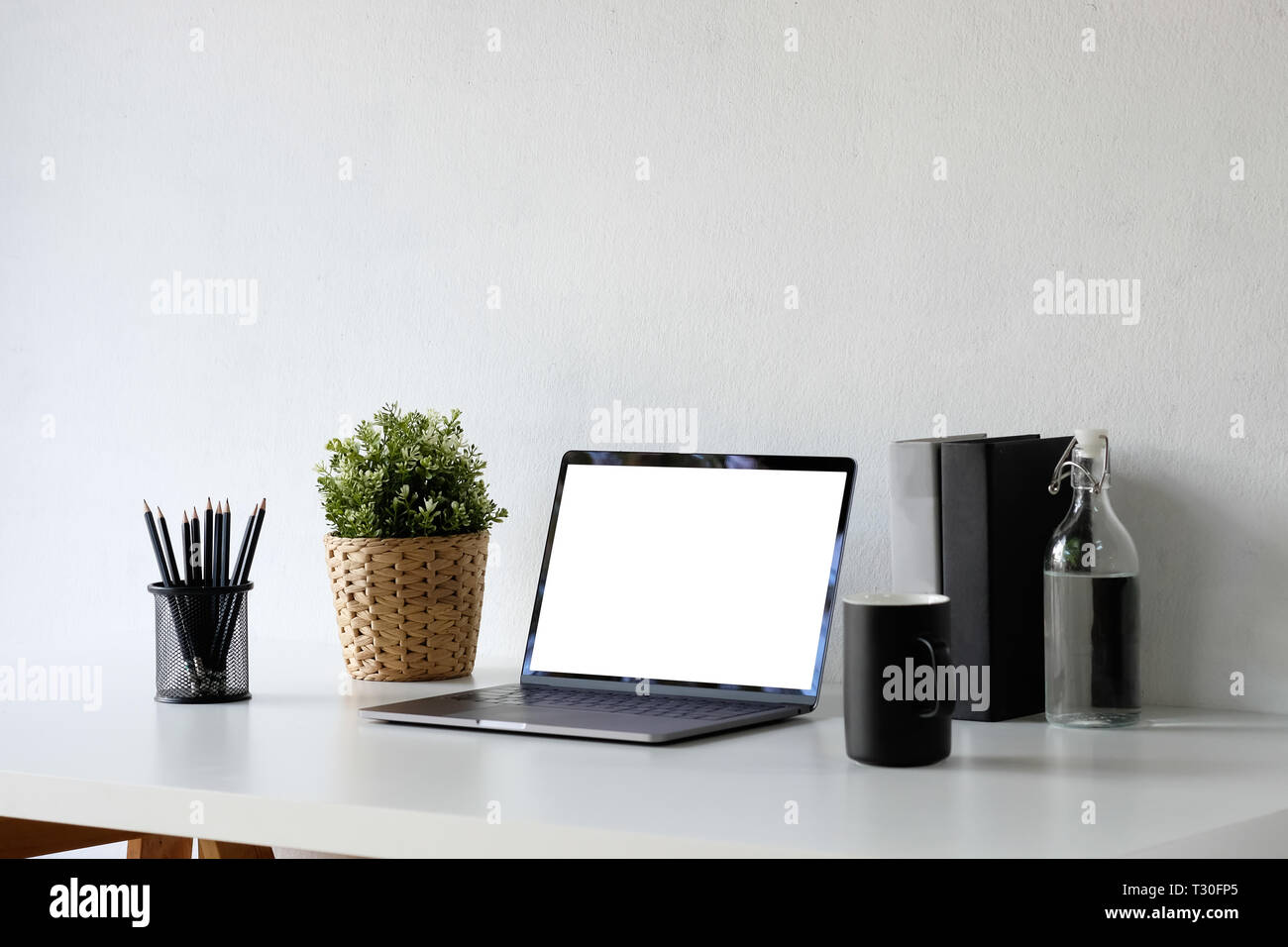 Workspace table with laptop computer, coffee mug, books and plant on ...