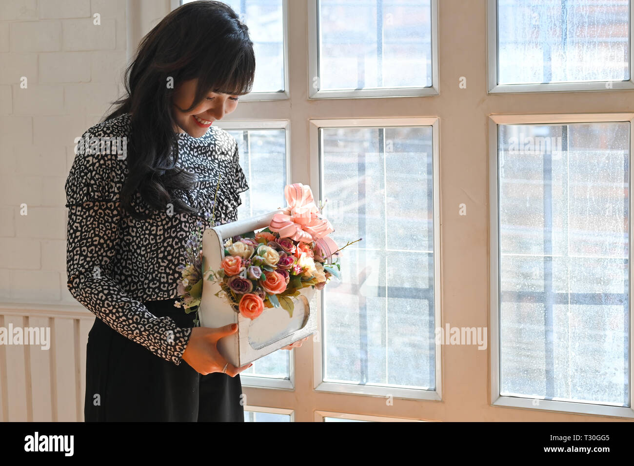 Woman giving a flower basket Stock Photo - Alamy