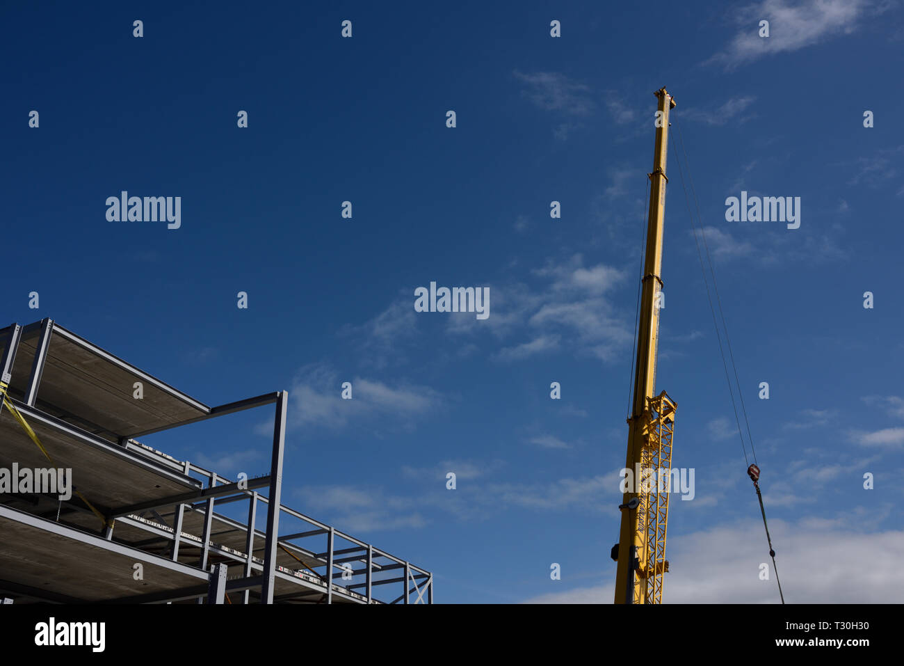 Steel skeleton frame and yellow telescopic hydraulic crane boom with ...